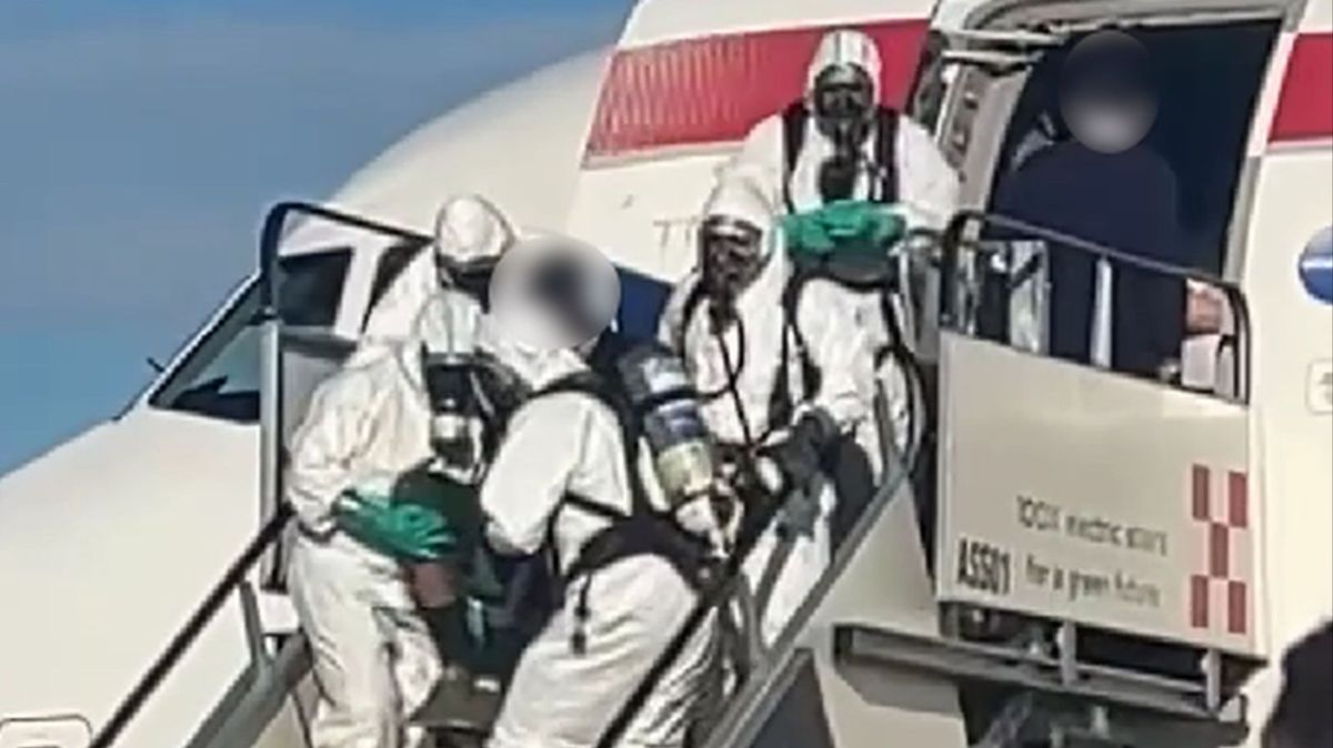 Moment firefighters in hazmat suits board plane from London after ...